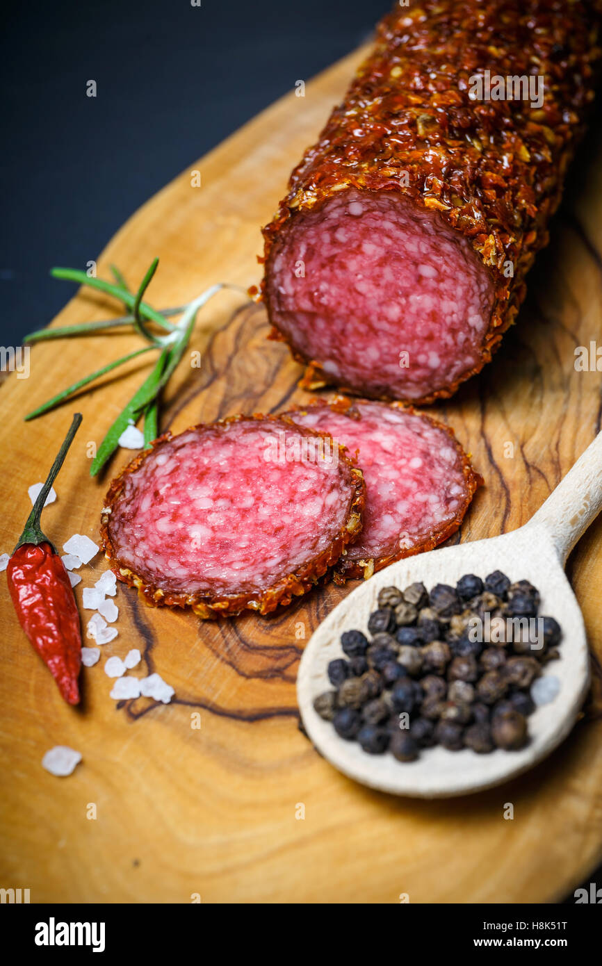 dried salami crusted in ground red pepper on dark background Stock ...