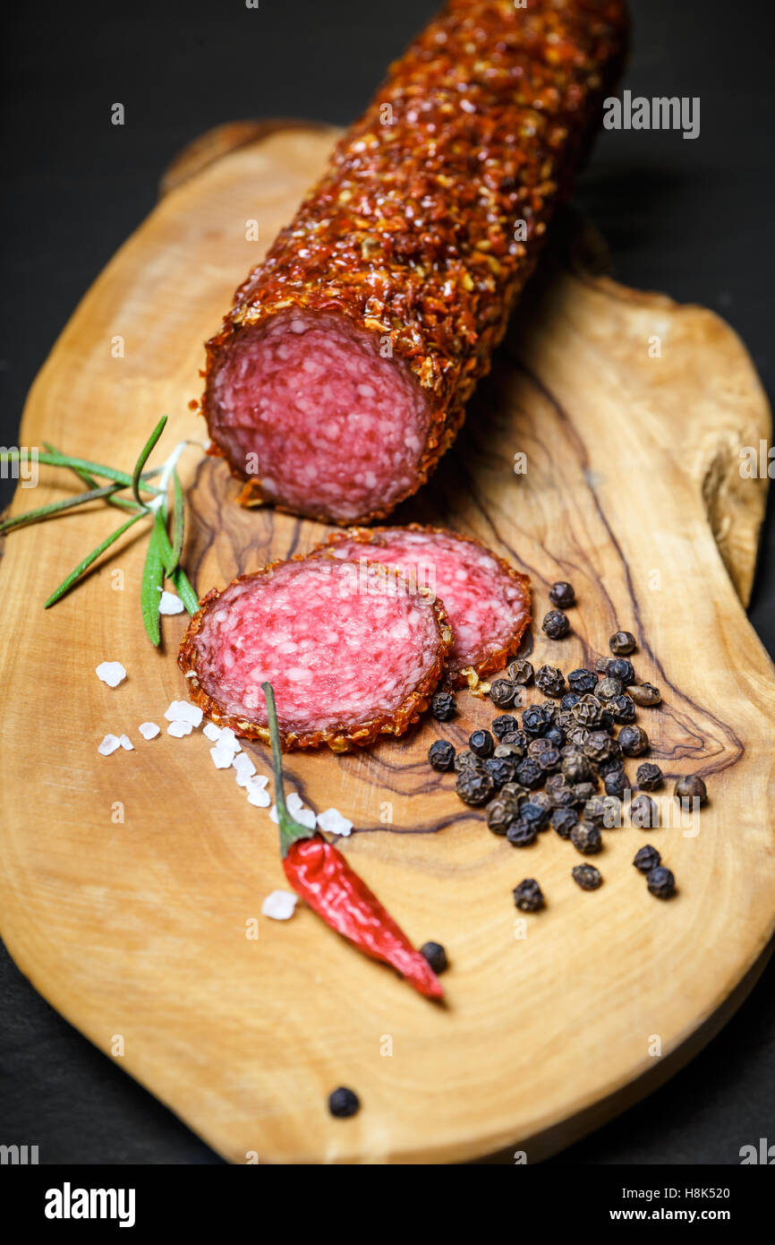 dried salami crusted in ground red pepper on dark background Stock ...