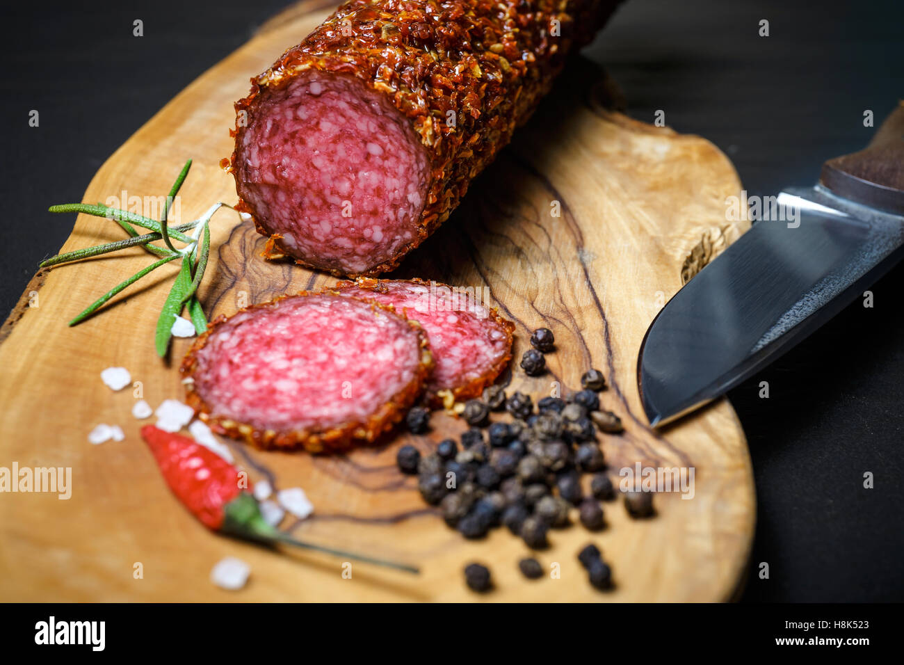 dried salami crusted in ground red pepper on dark background Stock ...
