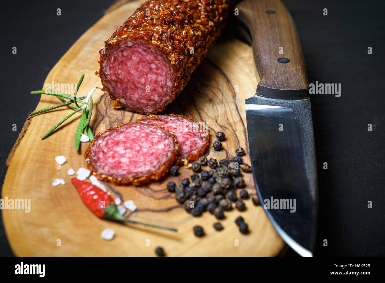 dried salami crusted in ground red pepper on dark background Stock ...