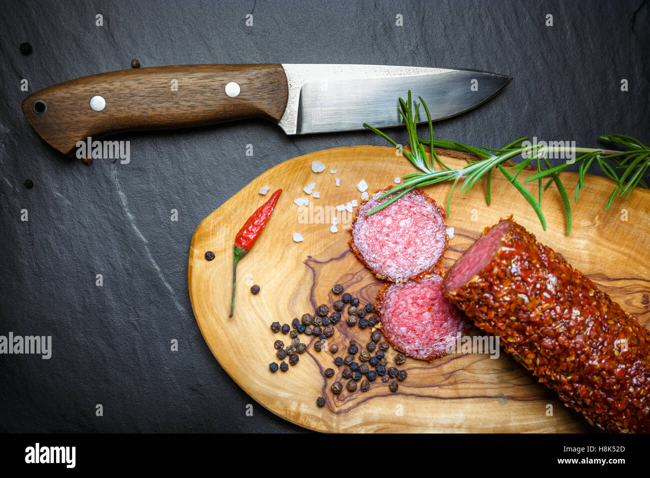 dried salami crusted in ground red pepper on dark background Stock ...