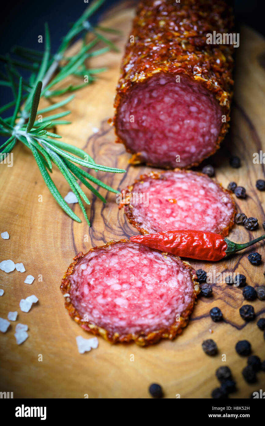 dried salami crusted in ground red pepper on dark background Stock ...