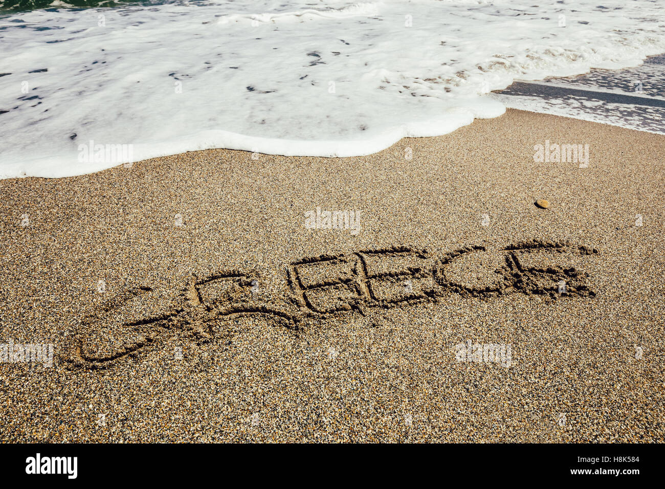 The word Greece written in the sand on beach Stock Photo - Alamy