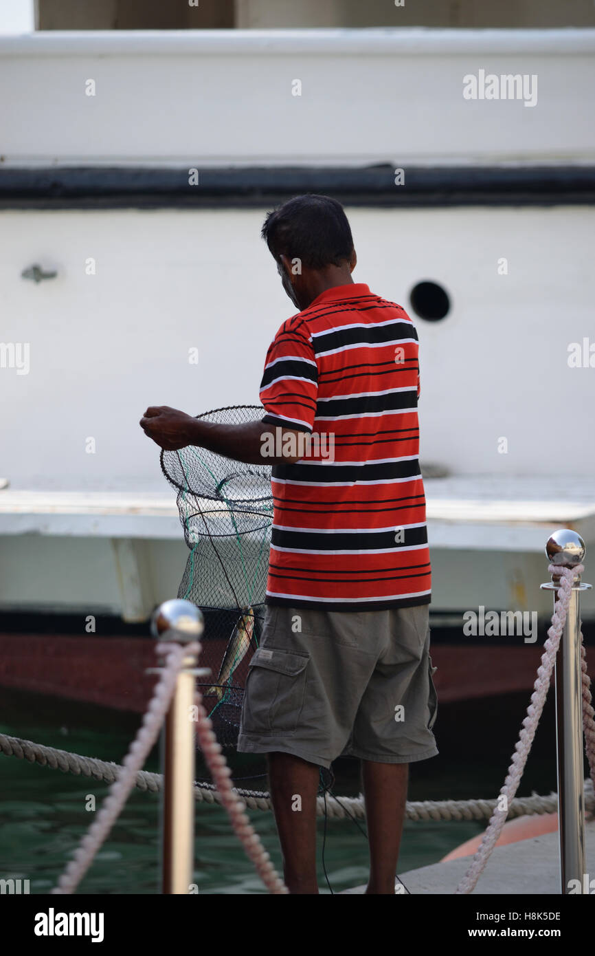 Man Fishing on dockside Stock Photo - Alamy