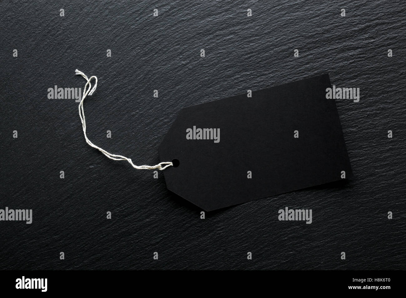 Blank black sale tag on dark slate background Stock Photo - Alamy