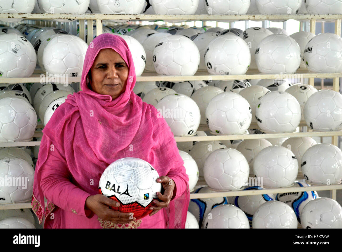 A Pakistani fairtrade football producer holds a Bala Sport football ...