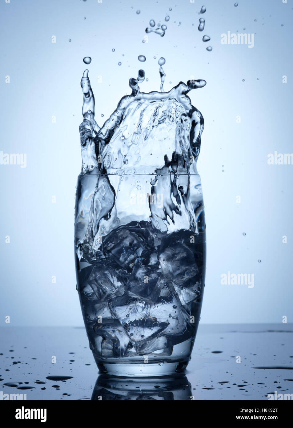 Water splash in glass with ice cubes Stock Photo - Alamy