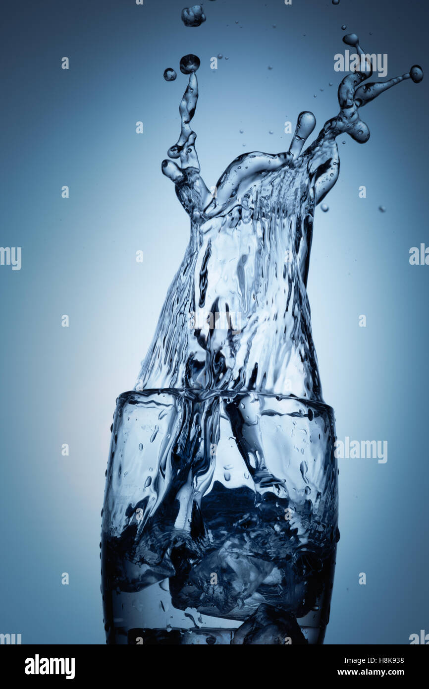 Water splash in glass with ice cubes Stock Photo - Alamy