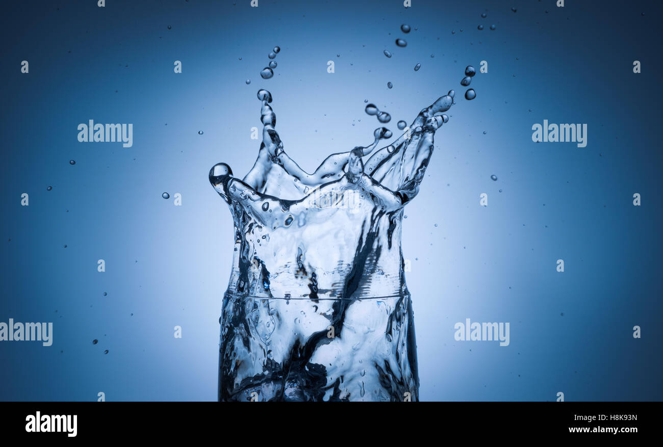 Water splash in glass with ice cubes Stock Photo - Alamy