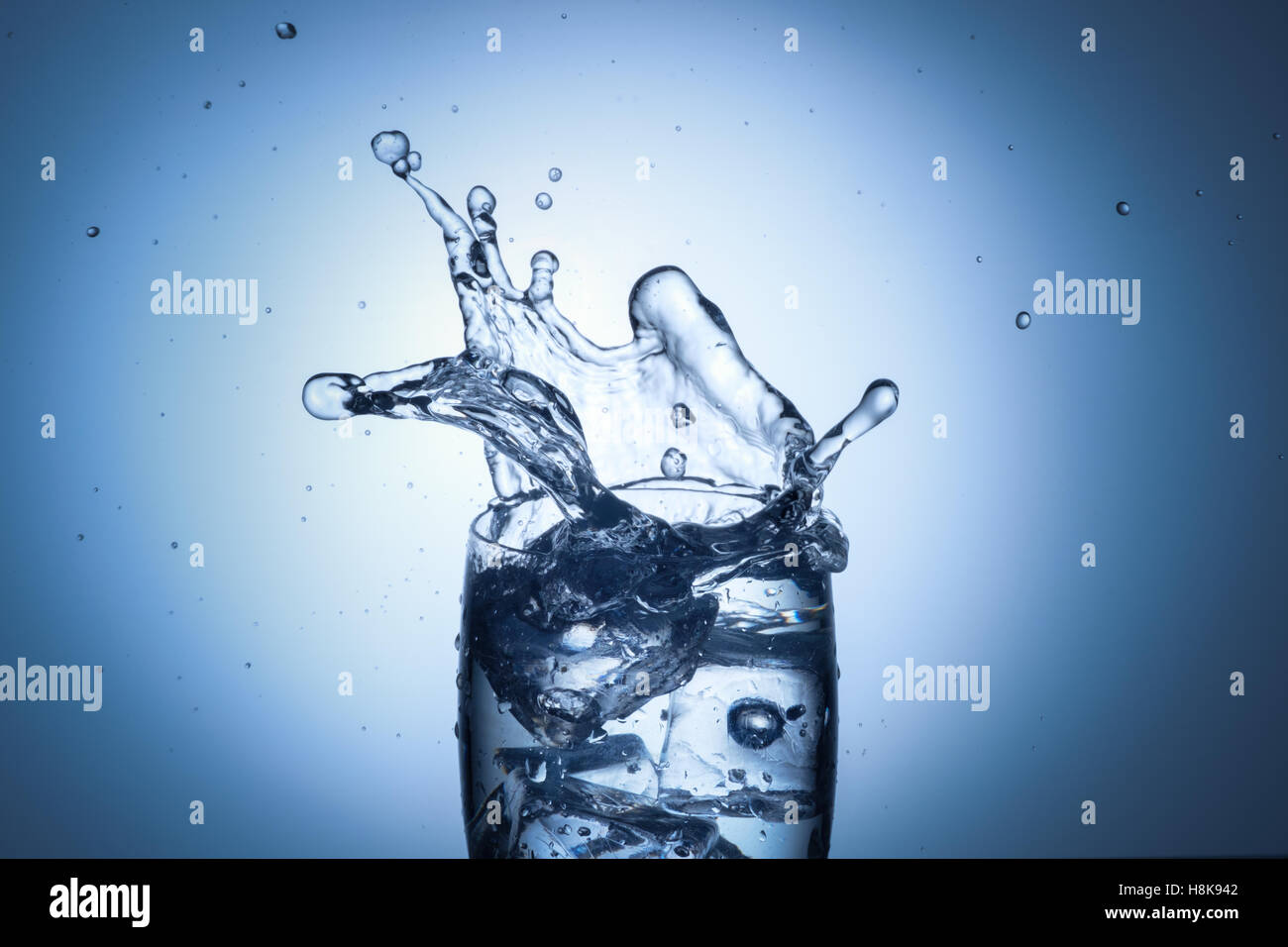 Water splash in glass with ice cubes Stock Photo - Alamy
