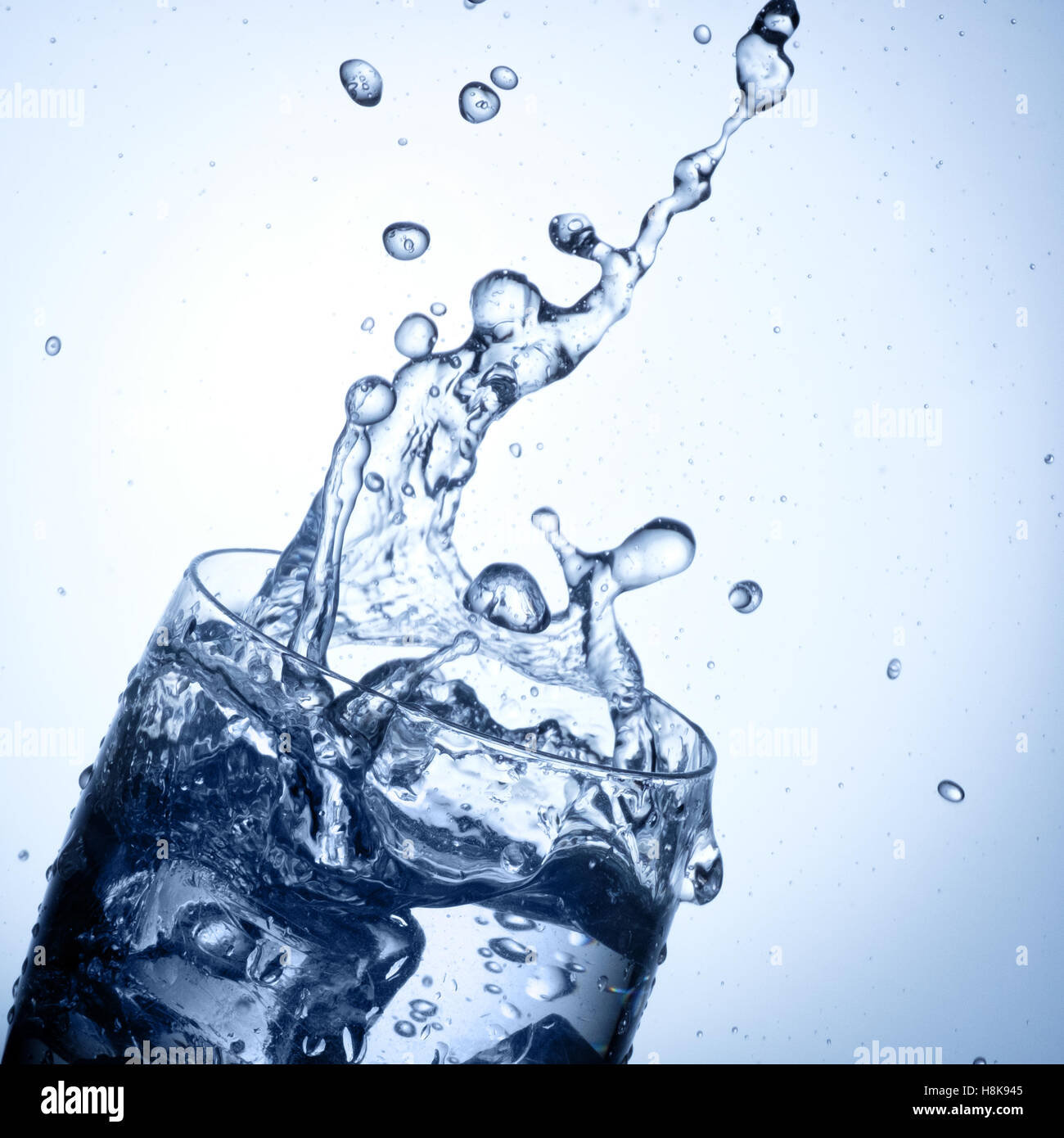 Water splash in glass with ice cubes Stock Photo - Alamy