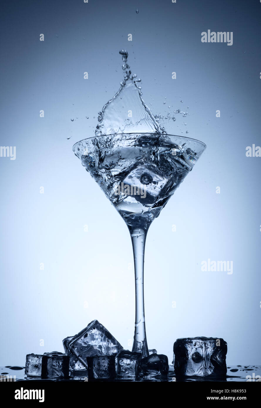 Water splash in glass with ice cubes Stock Photo - Alamy