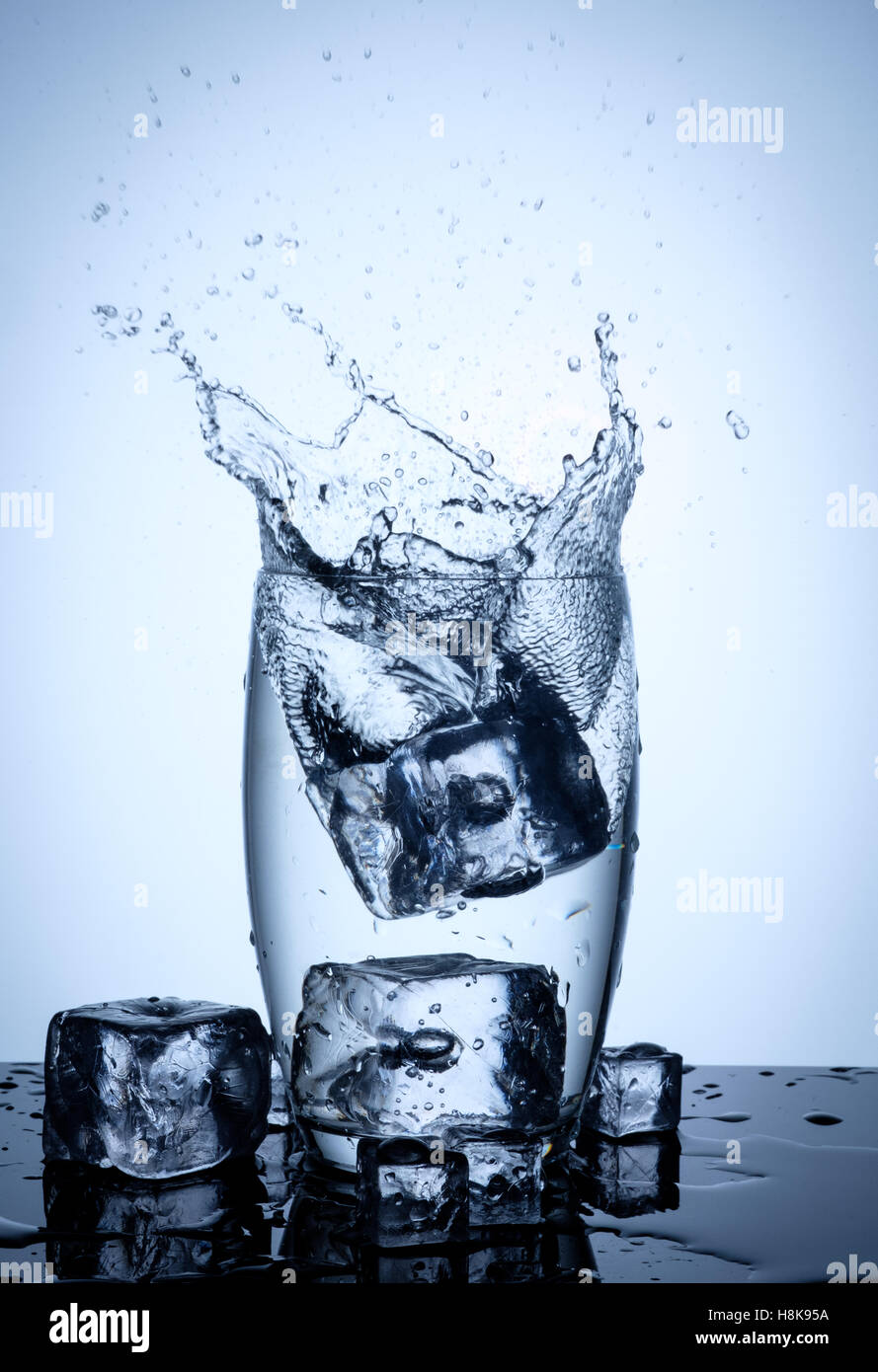 Water splash in glass with ice cubes Stock Photo - Alamy