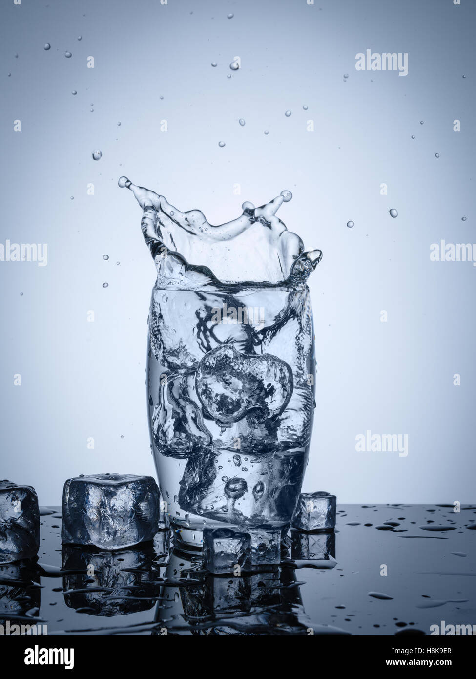 Water splash in glass with ice cubes Stock Photo - Alamy