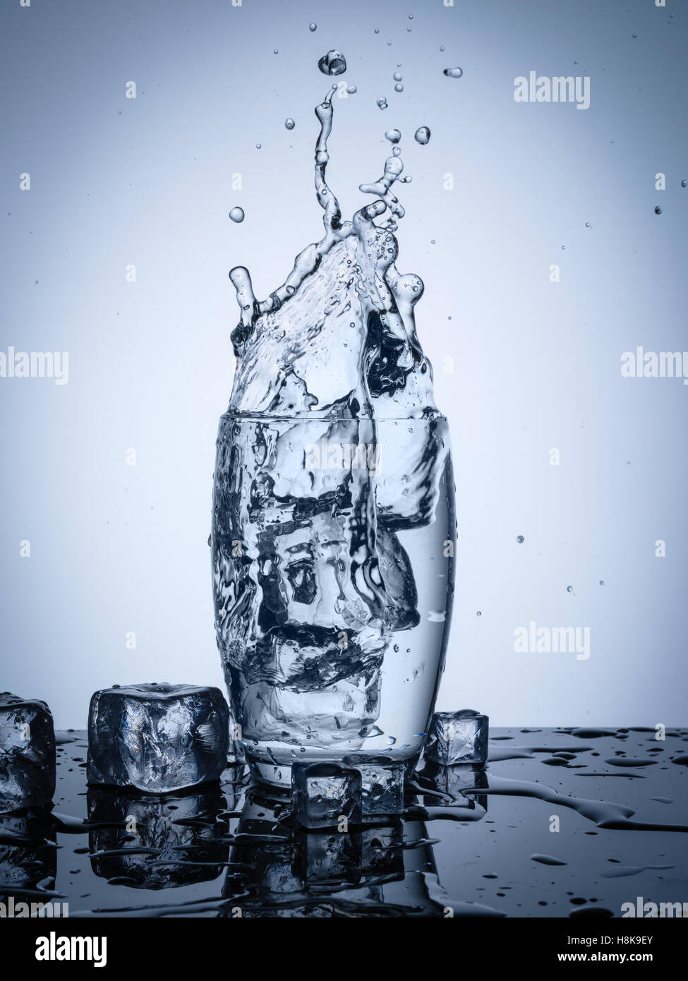 Water splash in glass with ice cubes Stock Photo - Alamy