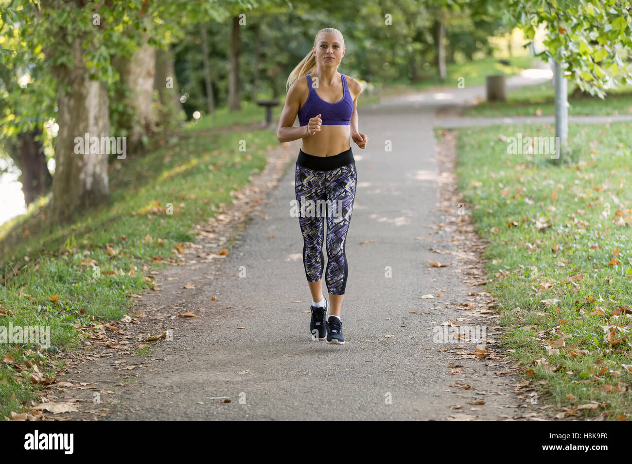 Jogging woman running in park in sunshine on beautiful summer day Stock ...