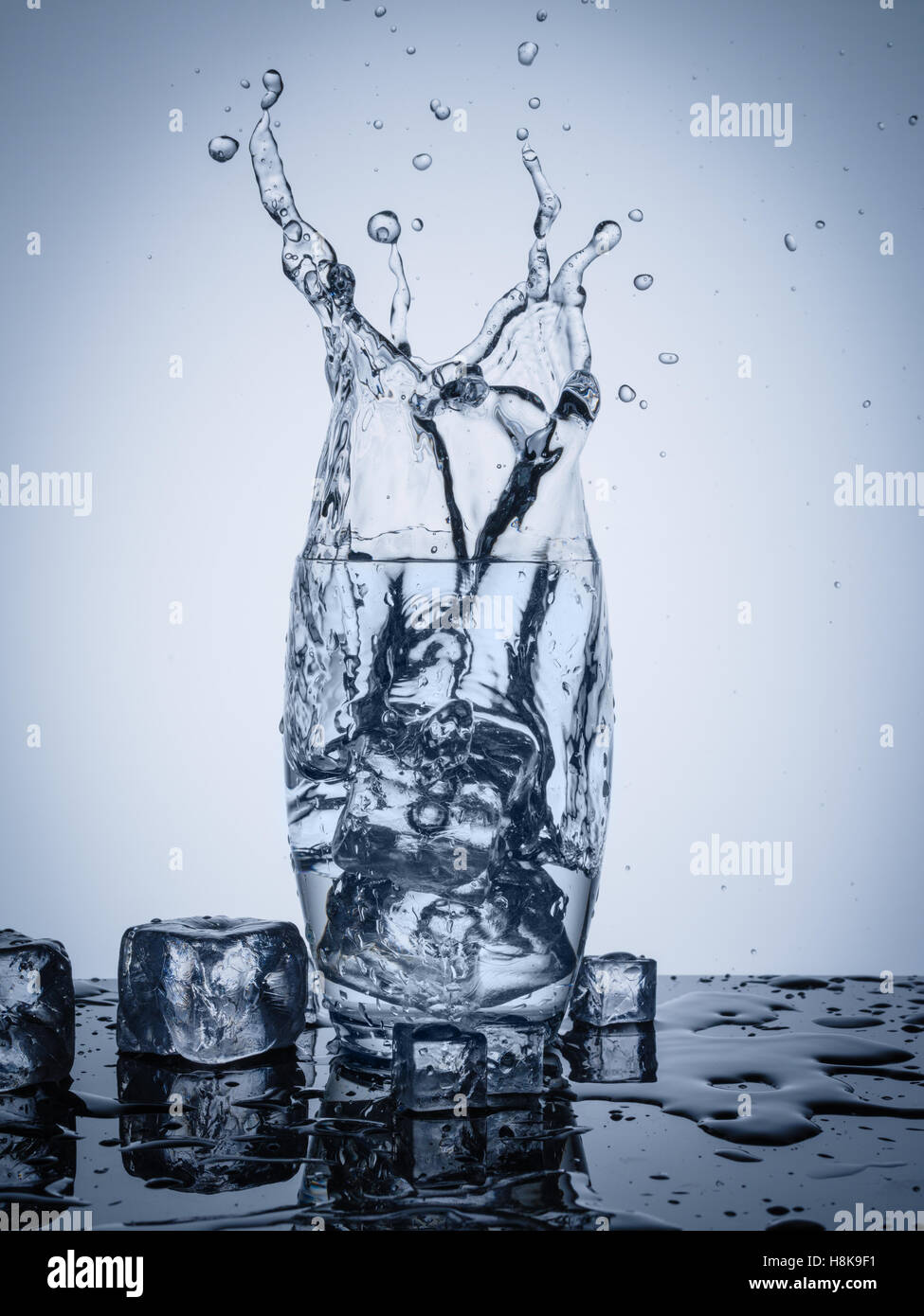 Water splash in glass with ice cubes Stock Photo - Alamy