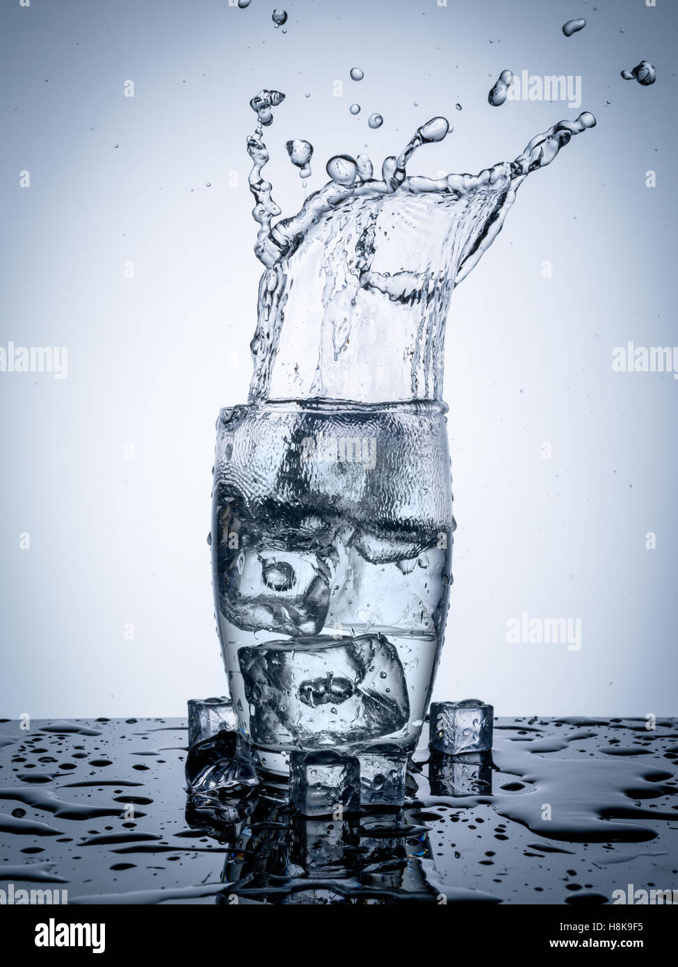 Water splash in glass with ice cubes Stock Photo - Alamy