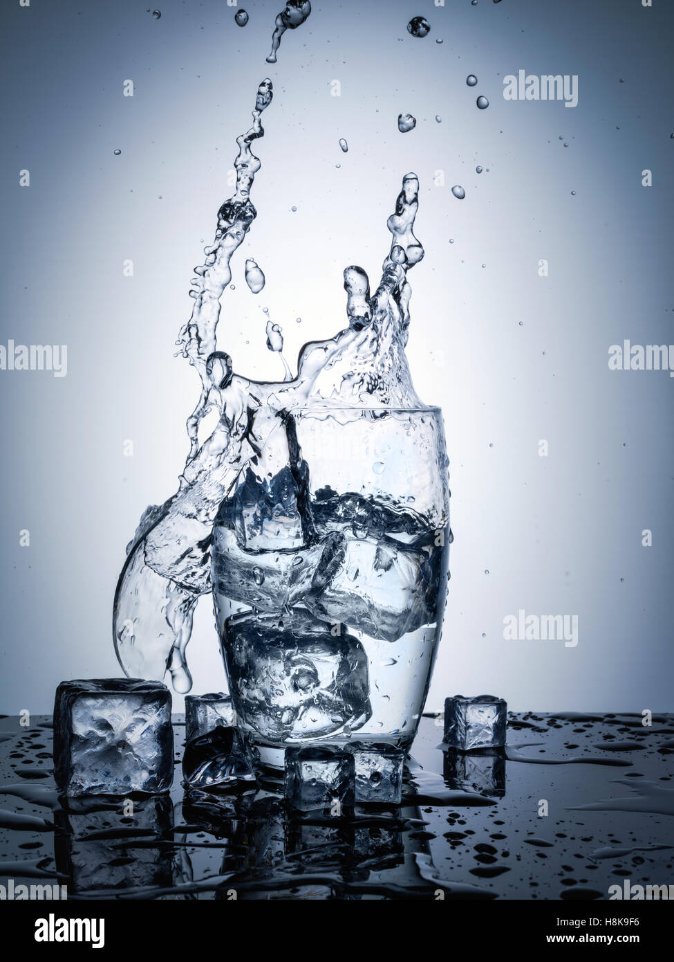 Water splash in glass with ice cubes Stock Photo - Alamy