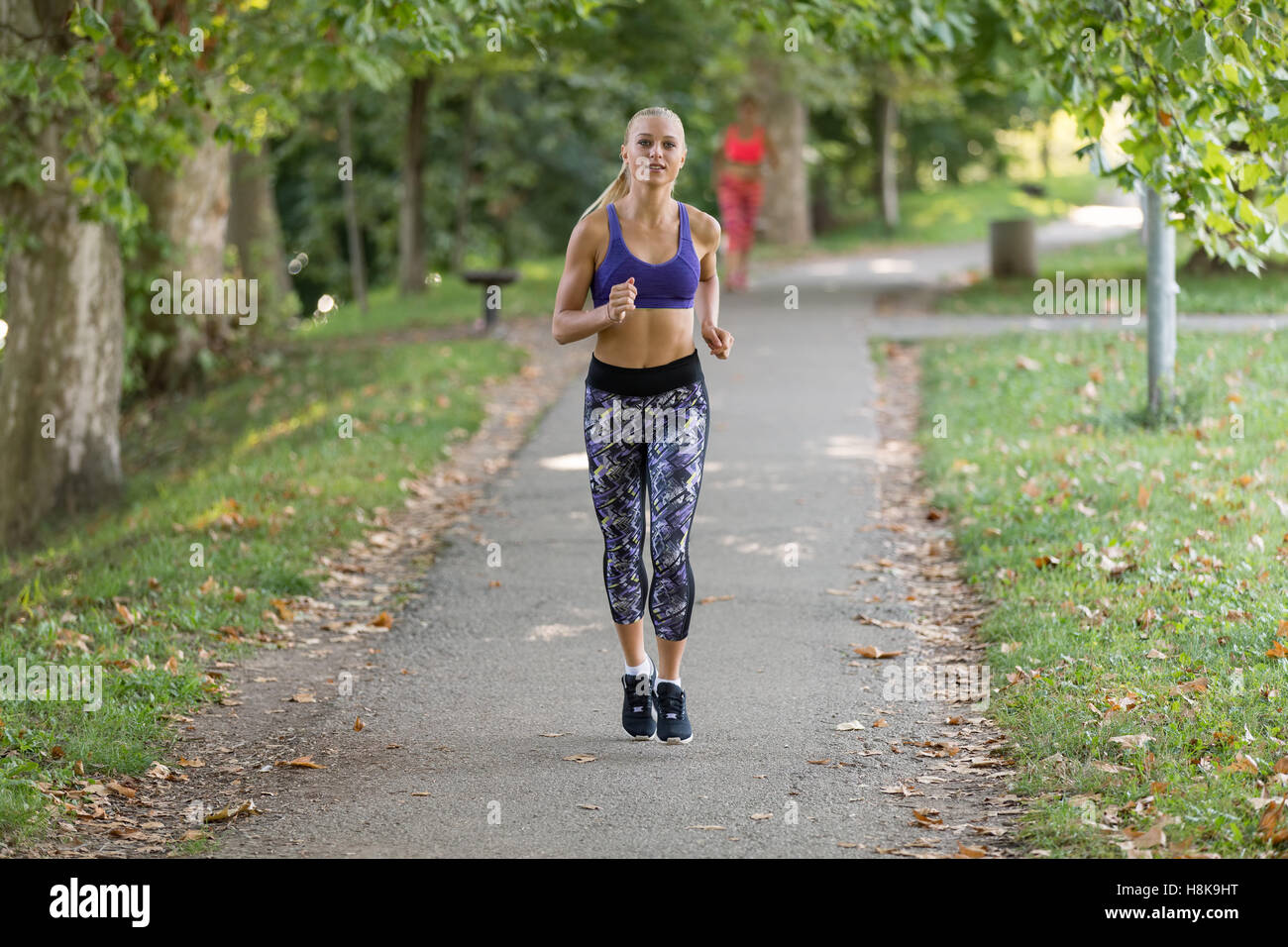 Jogging woman running in park in sunshine on beautiful summer day Stock ...