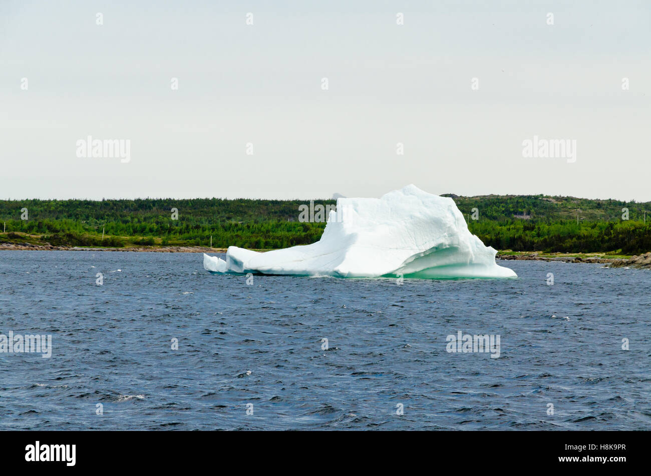 Bright white iceberg on dark water and rock background Stock Photo - Alamy