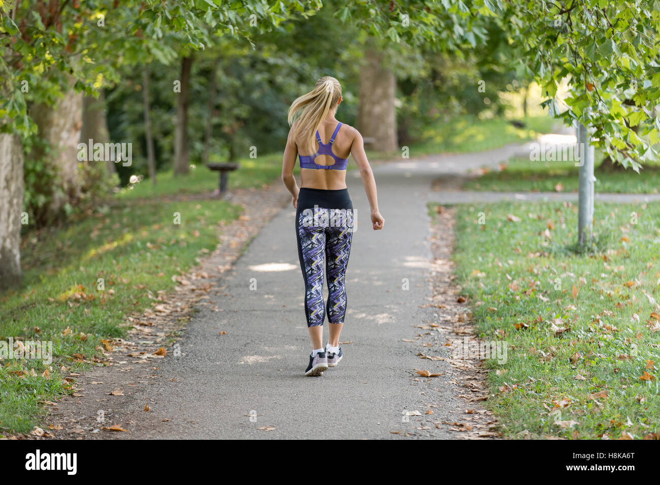 Jogging woman running in park in sunshine on beautiful summer day Stock ...