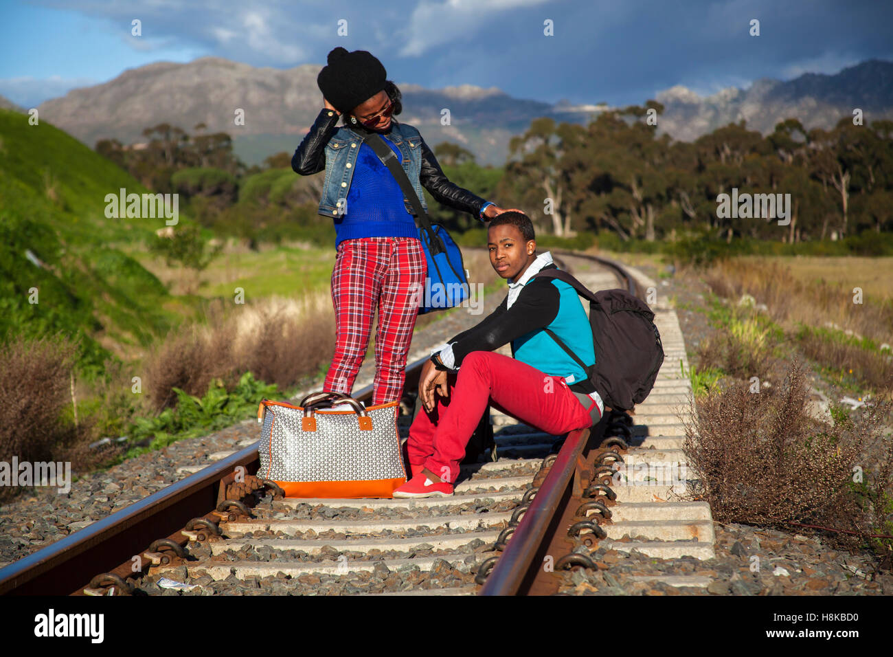 african guy and girl waiting for train on the tracks Stock Photo - Alamy