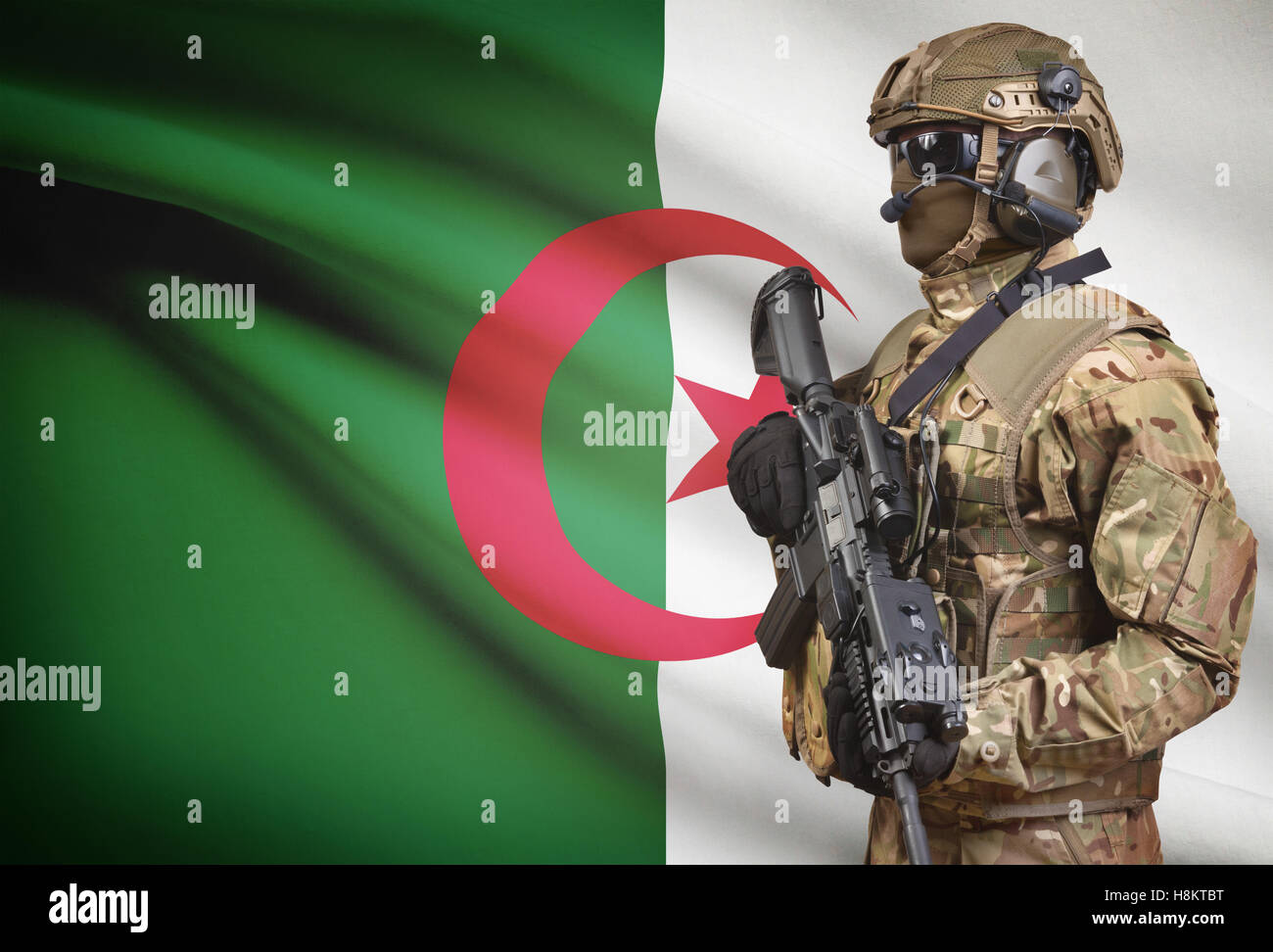Soldier in helmet holding machine gun with national flag on background ...