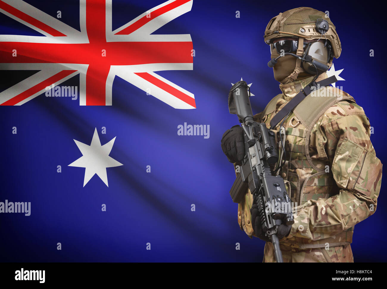 Soldier in helmet holding machine gun with national flag on background ...