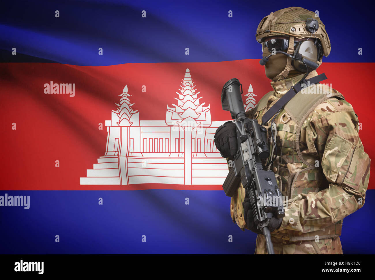 Soldier in helmet holding machine gun with national flag on background ...