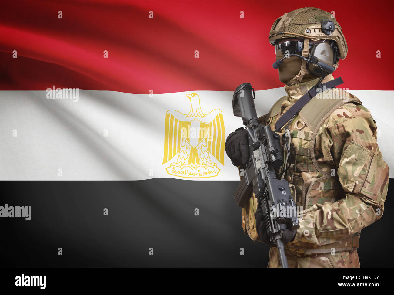 Soldier in helmet holding machine gun with national flag on background ...