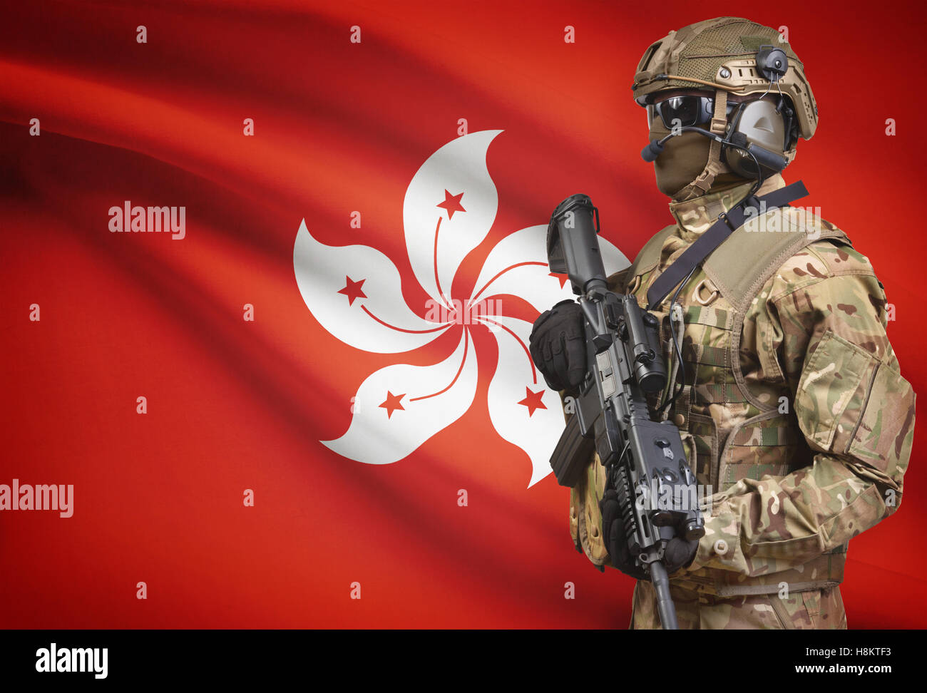 Soldier in helmet holding machine gun with national flag on background ...