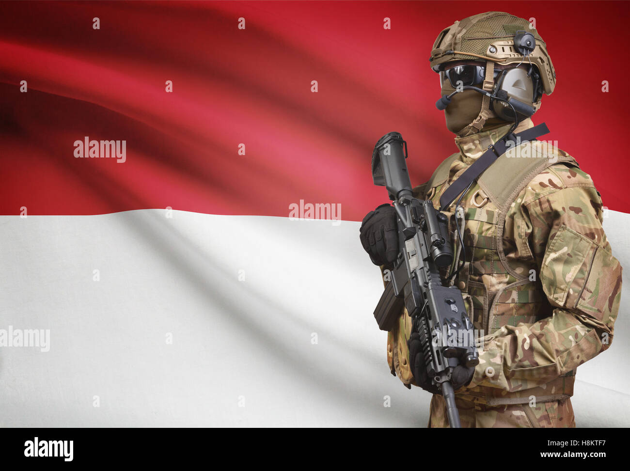 Soldier in helmet holding machine gun with national flag on background ...