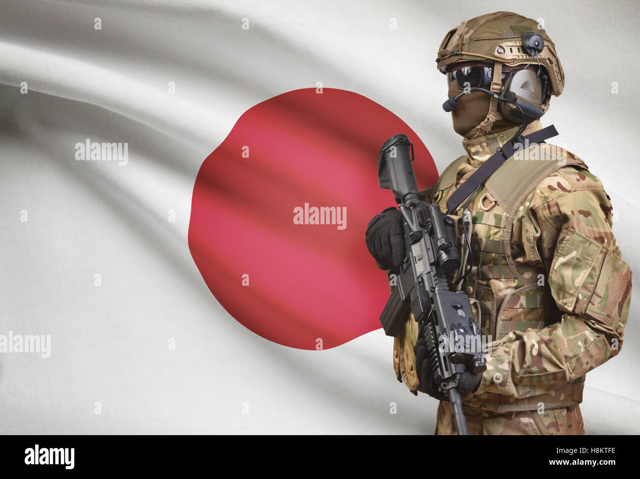Soldier in helmet holding machine gun with national flag on background ...