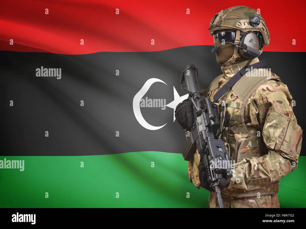 Soldier in helmet holding machine gun with national flag on background ...