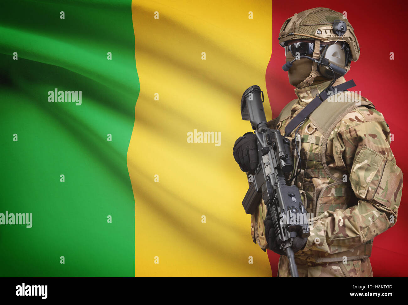 Soldier in helmet holding machine gun with national flag on background ...