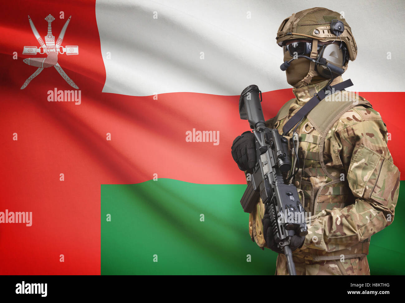 Soldier in helmet holding machine gun with national flag on background ...