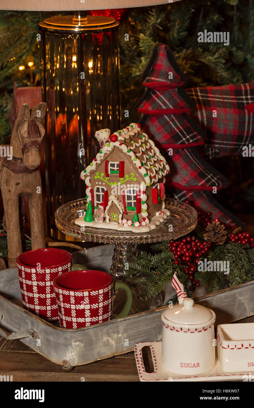 Gingerbread house on display and surrounded by holiday decorations ...
