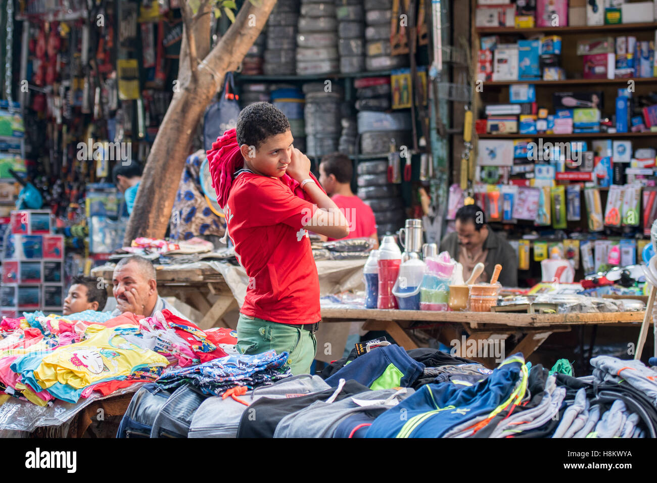 Cairo, Egypt. Young Egyptian boy selling clothes and holding a stack of ...