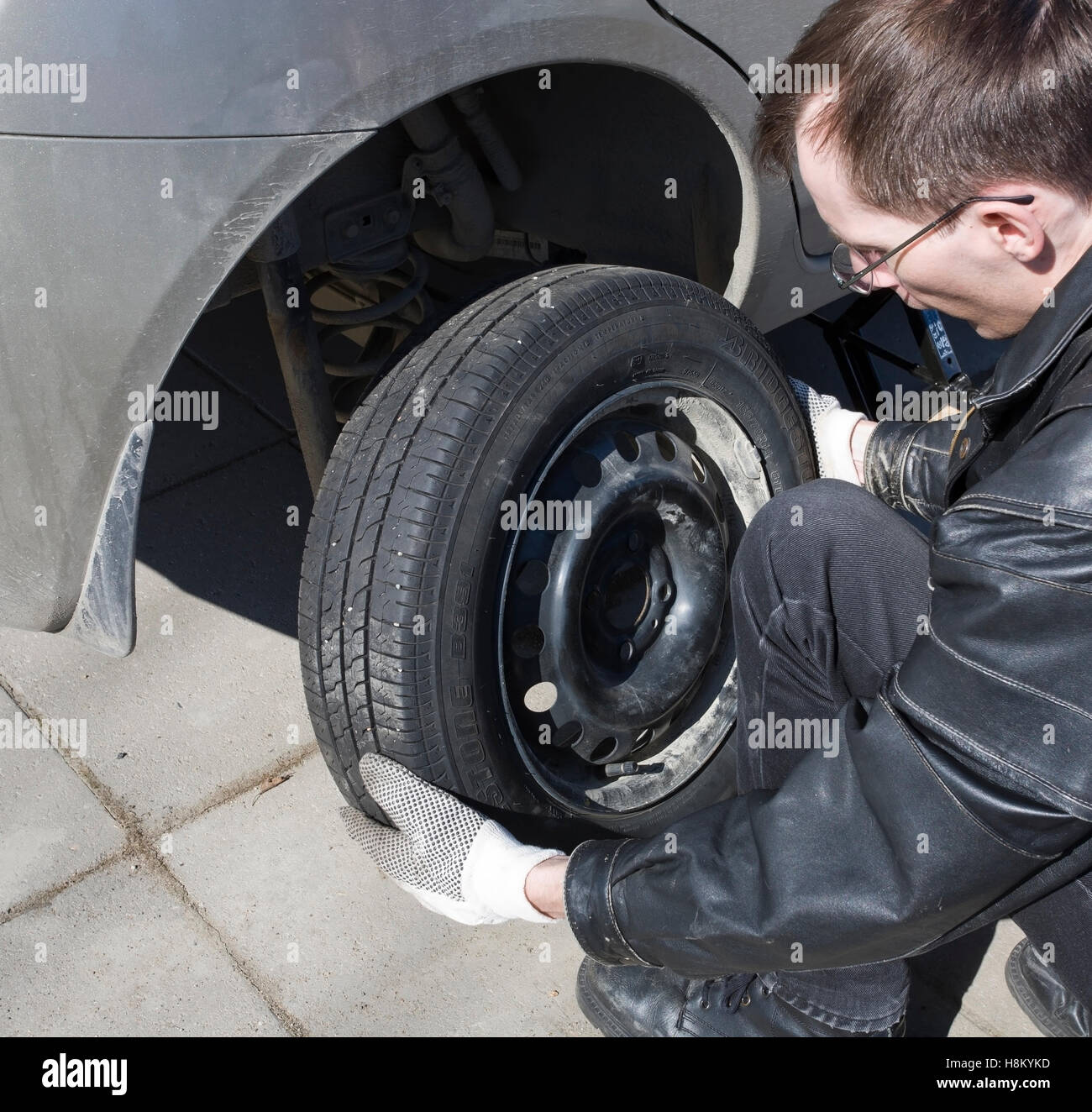 man changing car tyre outdoors, Finland Stock Photo - Alamy