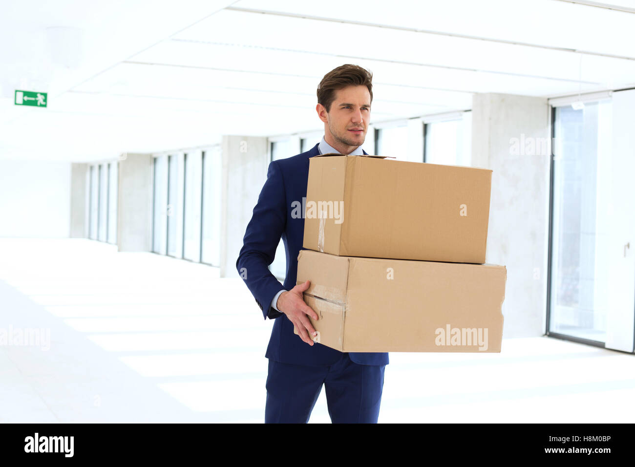 Young businessman carrying cardboard boxes in new office Stock Photo ...