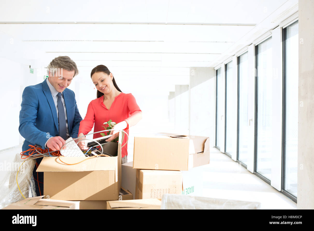 Business people unpacking cardboard boxes in new office Stock Photo - Alamy