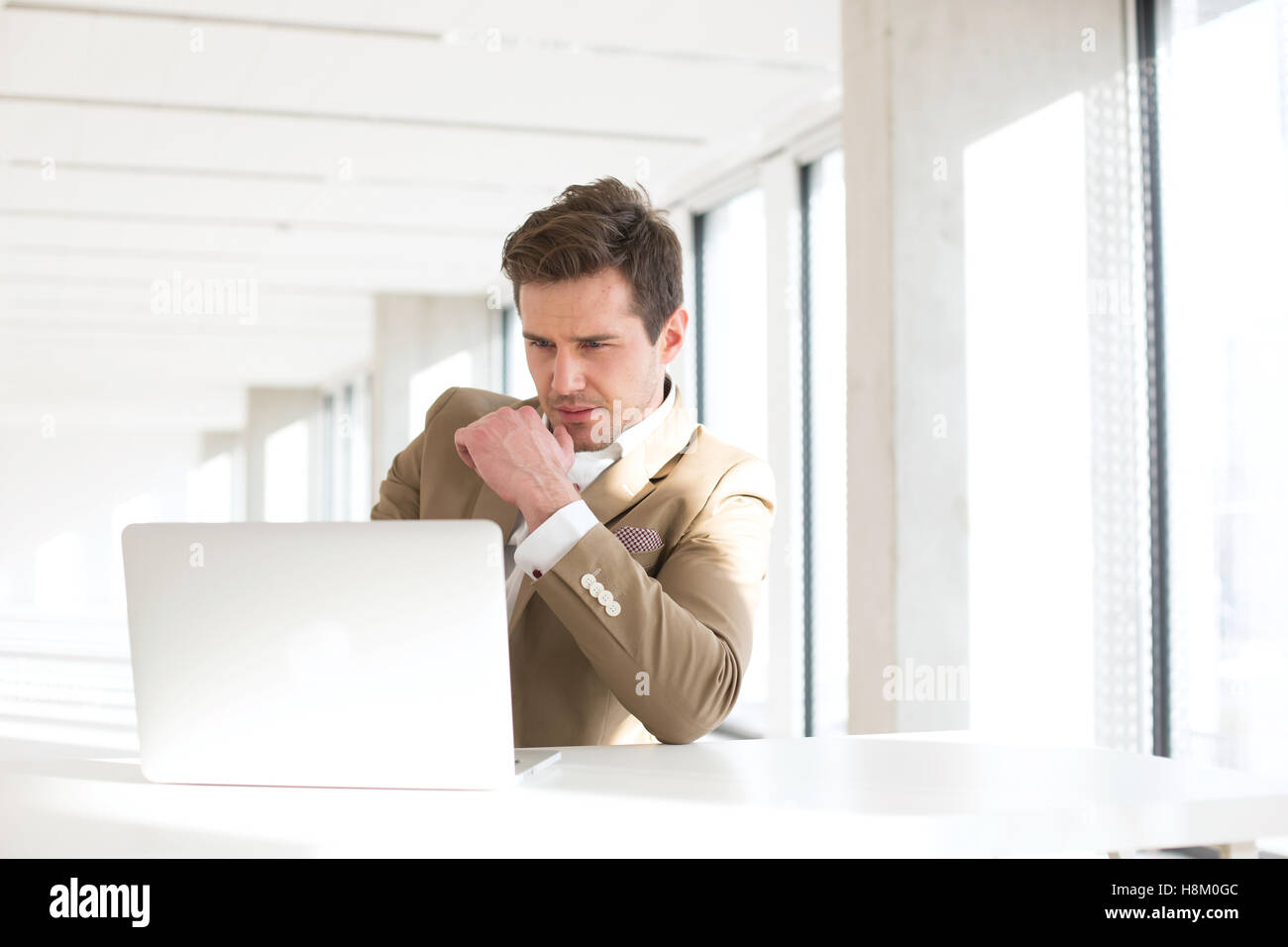 Businessman looking at laptop at office desk hi-res stock photography ...