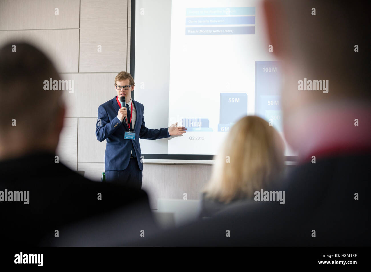 Businessman giving presentation in seminar hall at convention center ...