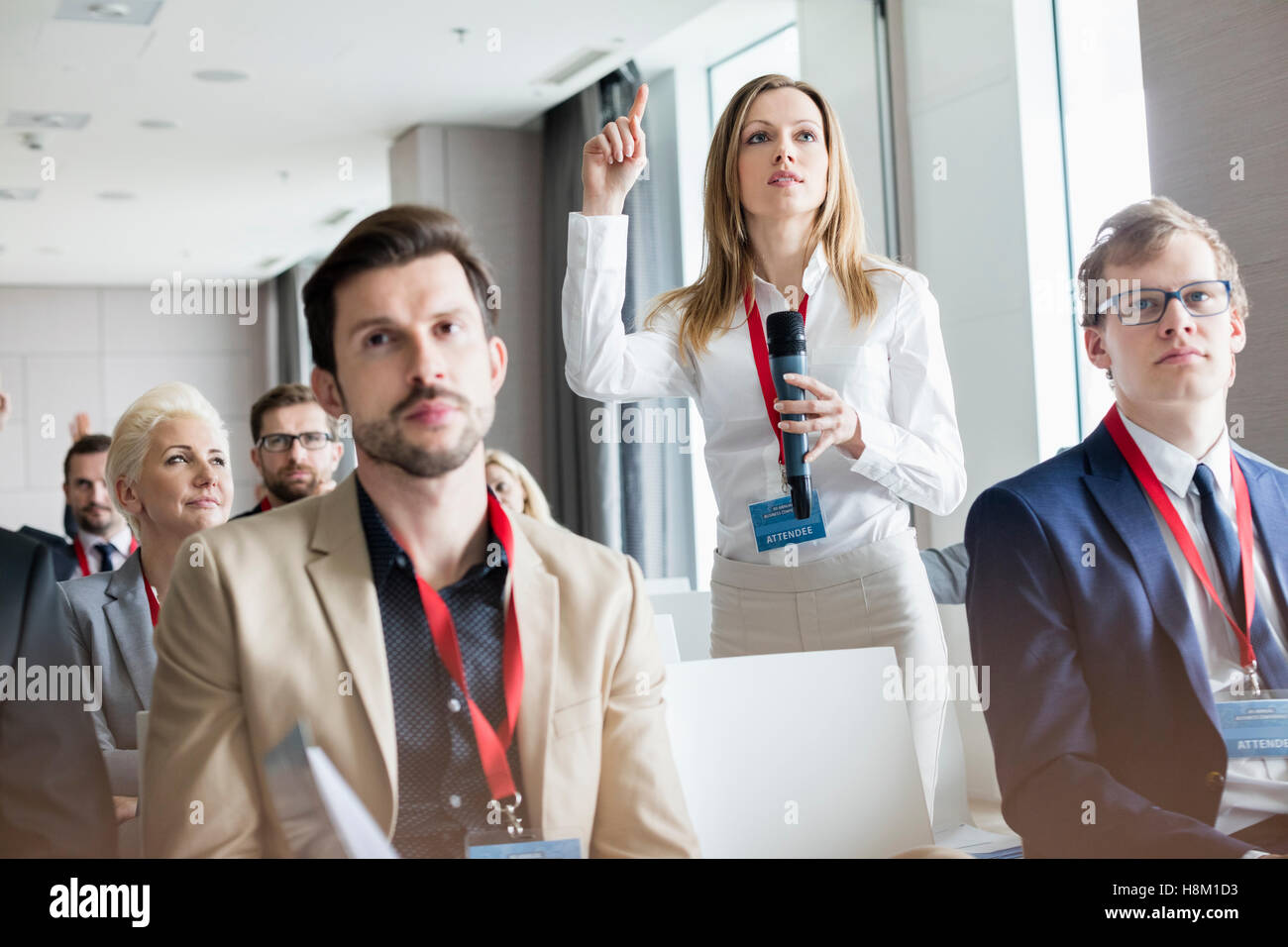Confident businesswoman asking questions during seminar Stock Photo - Alamy