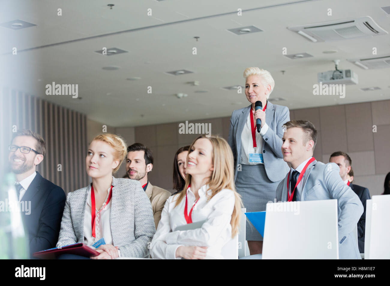 Smiling businesswoman asking questions during seminar Stock Photo - Alamy