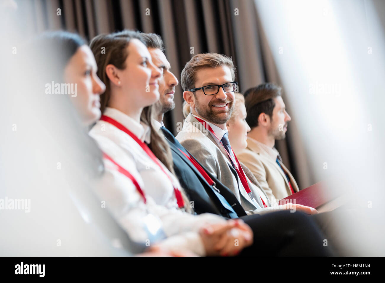 Portrait of confident businessman sitting in seminar hall Stock Photo ...