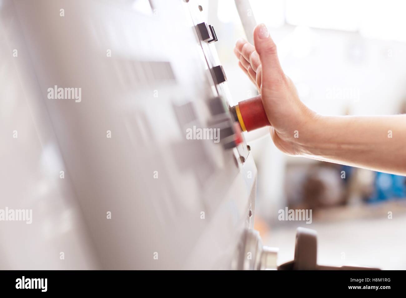 Cropped image of manual worker pressing button on control panel at ...