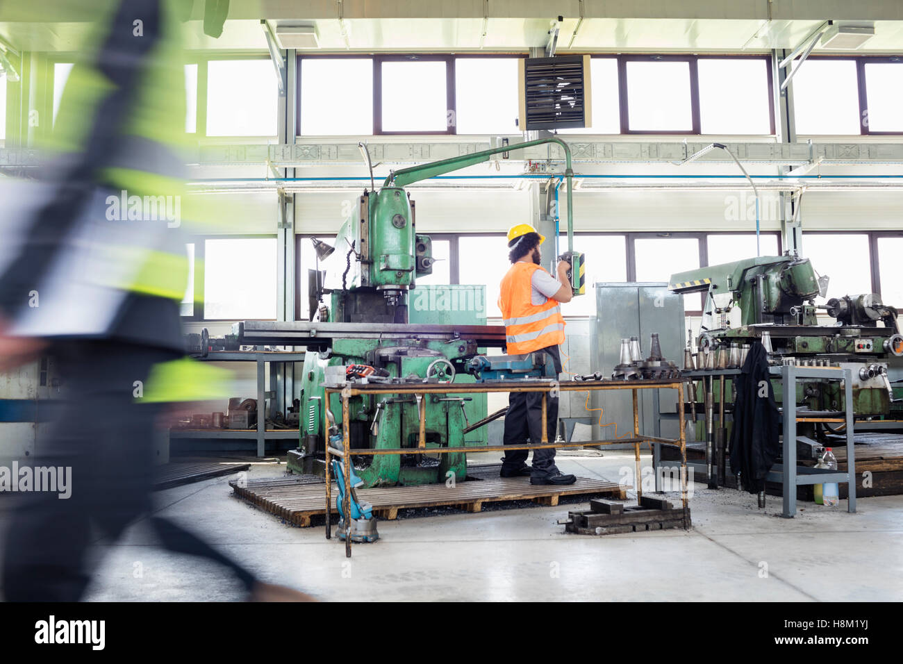 Manual worker operating machinery at metal industry Stock Photo - Alamy