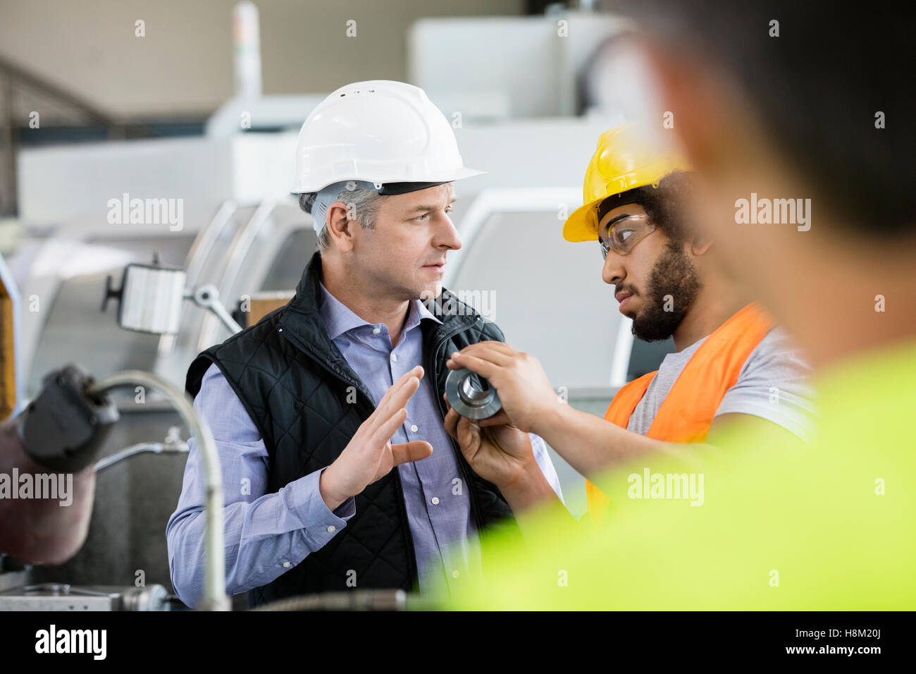 Male inspector having discussion with worker in metal industry Stock ...
